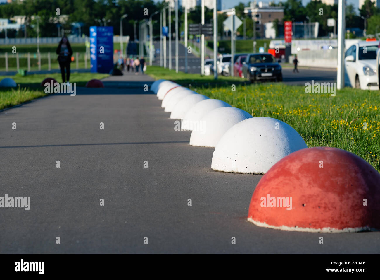 Round spheric concrete barriers of red and white color protect from the ...