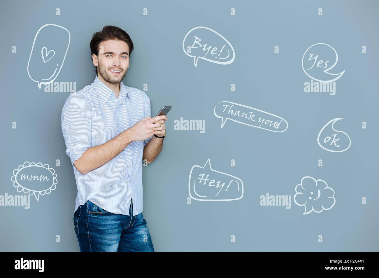 Handsome young student smiling while typing messages Stock Photo - Alamy Handsome young student smiling while typing messages Stock Photo - Alamy