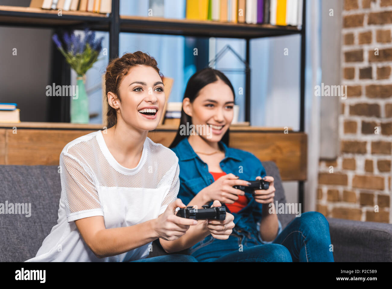 beautiful young multiethnic women playing with joysticks together Stock ...
