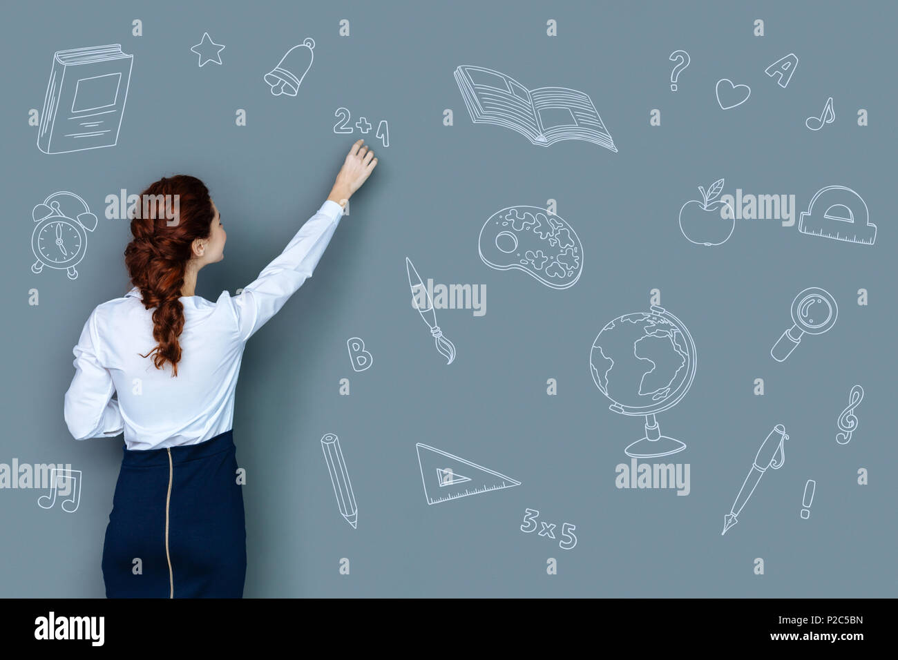Clever teacher explaining a new topic and writing on the blackboard ...