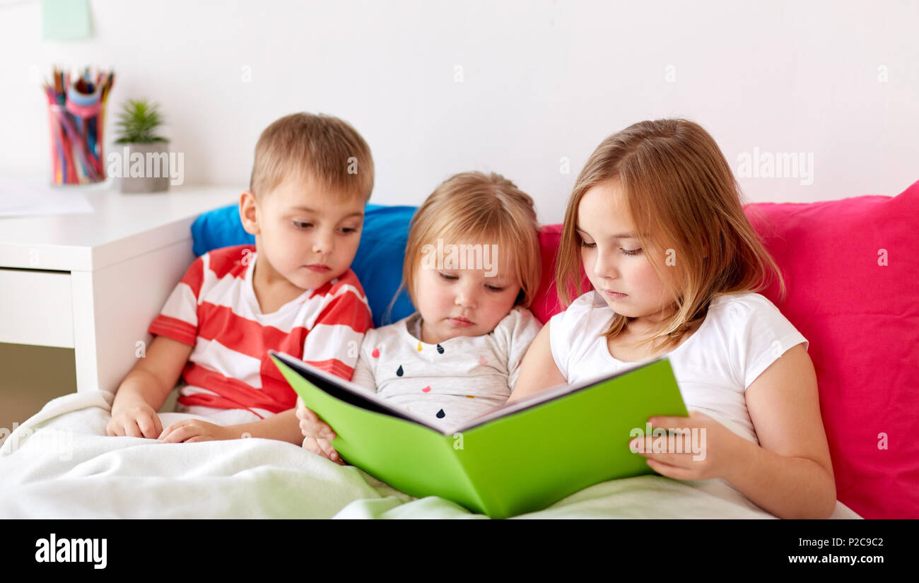little kids reading book in bed at home Stock Photo - Alamy