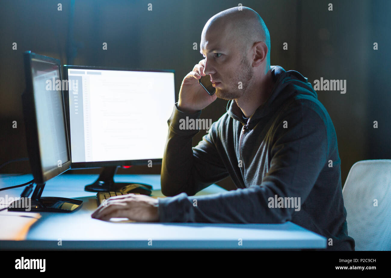 hacker with program on computer calling on cell Stock Photo - Alamy