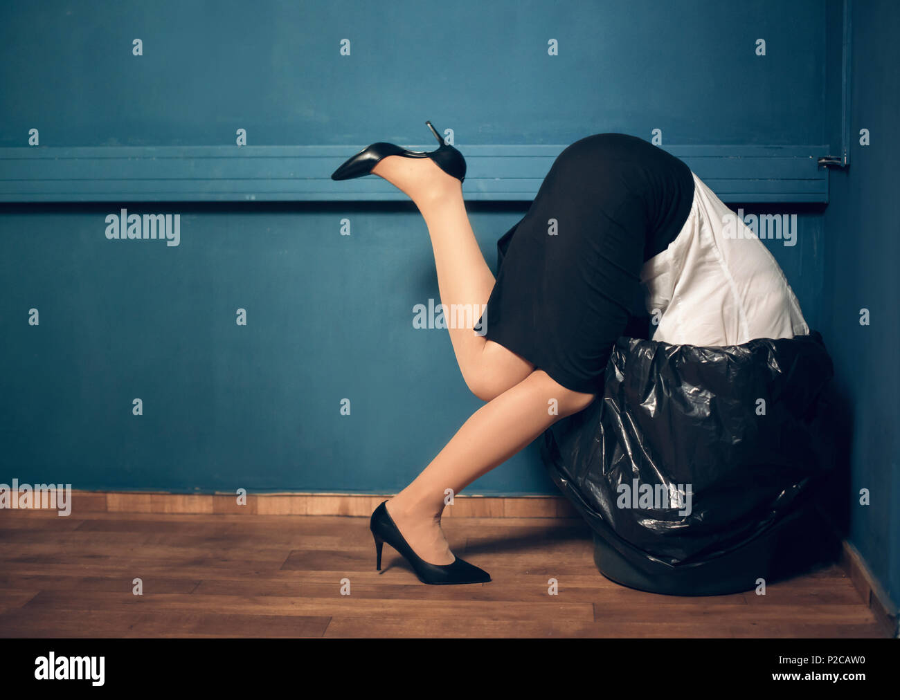 Woman with her head in garbage bin Stock Photo - Alamy
