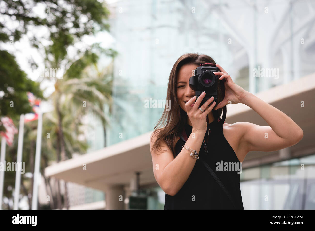 Woman clicking photo with digital camera Stock Photo - Alamy