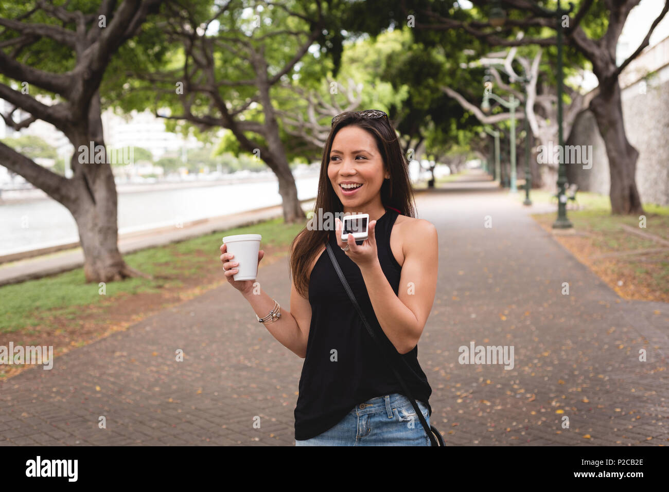 Woman walking holding mobile phone hi-res stock photography and images ...