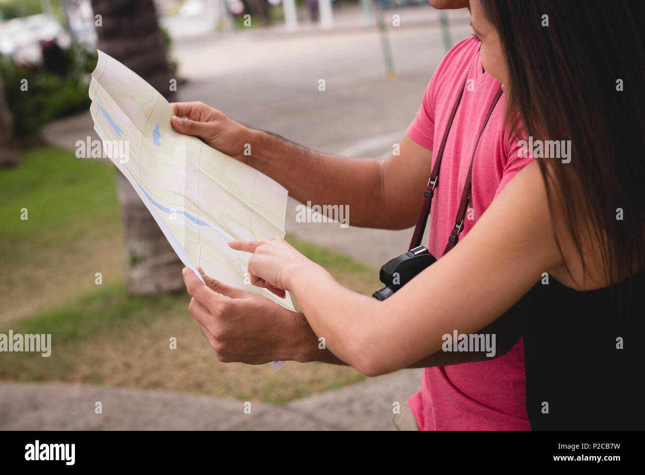 Couple looking at map in city street Stock Photo - Alamy