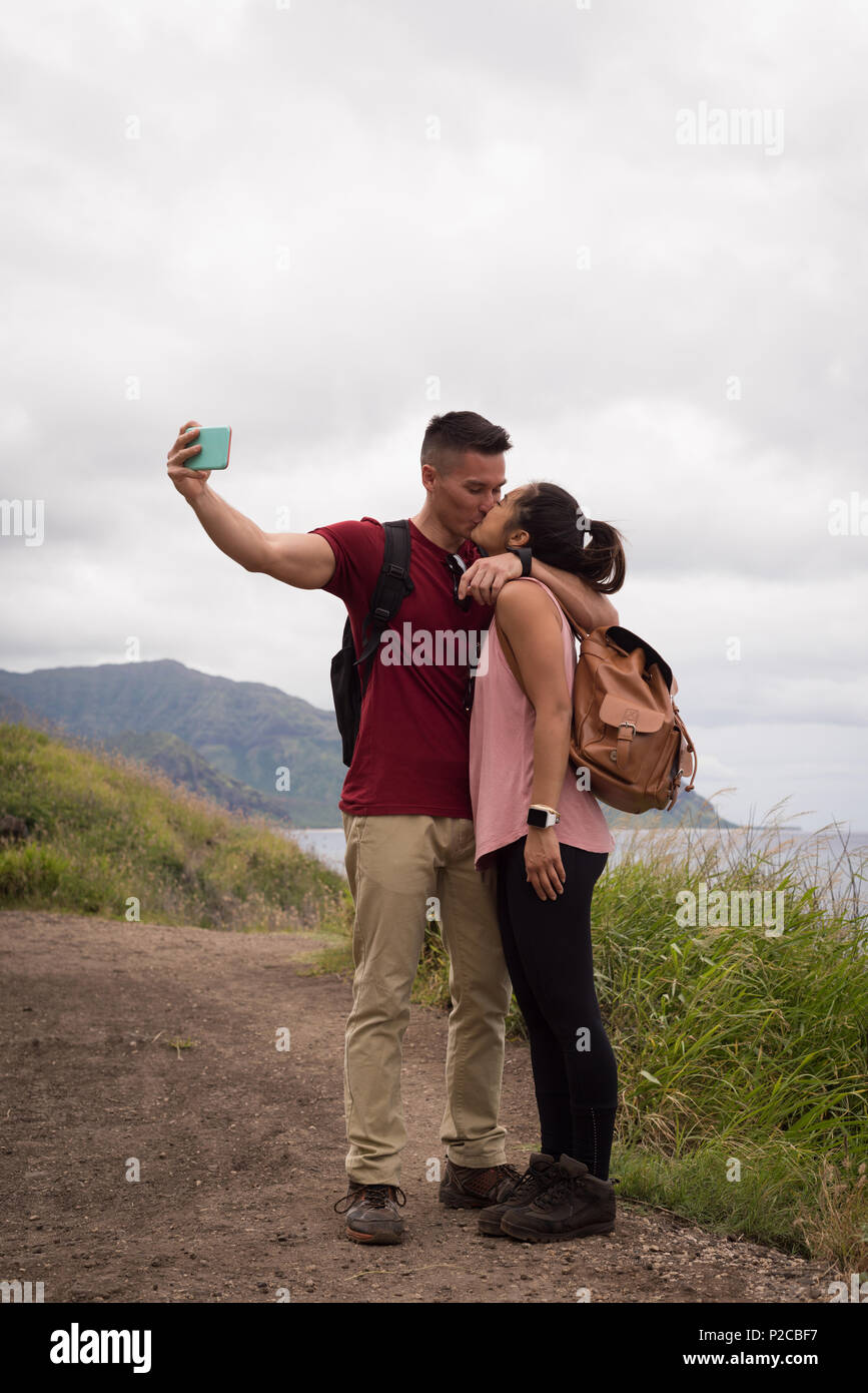 Couple kissing each other while taking selfie with mobile phone Stock ...
