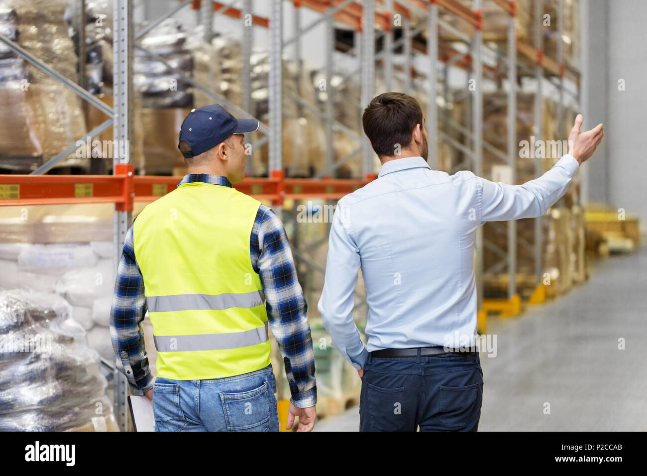 businessman showing warehouse to worker Stock Photo - Alamy