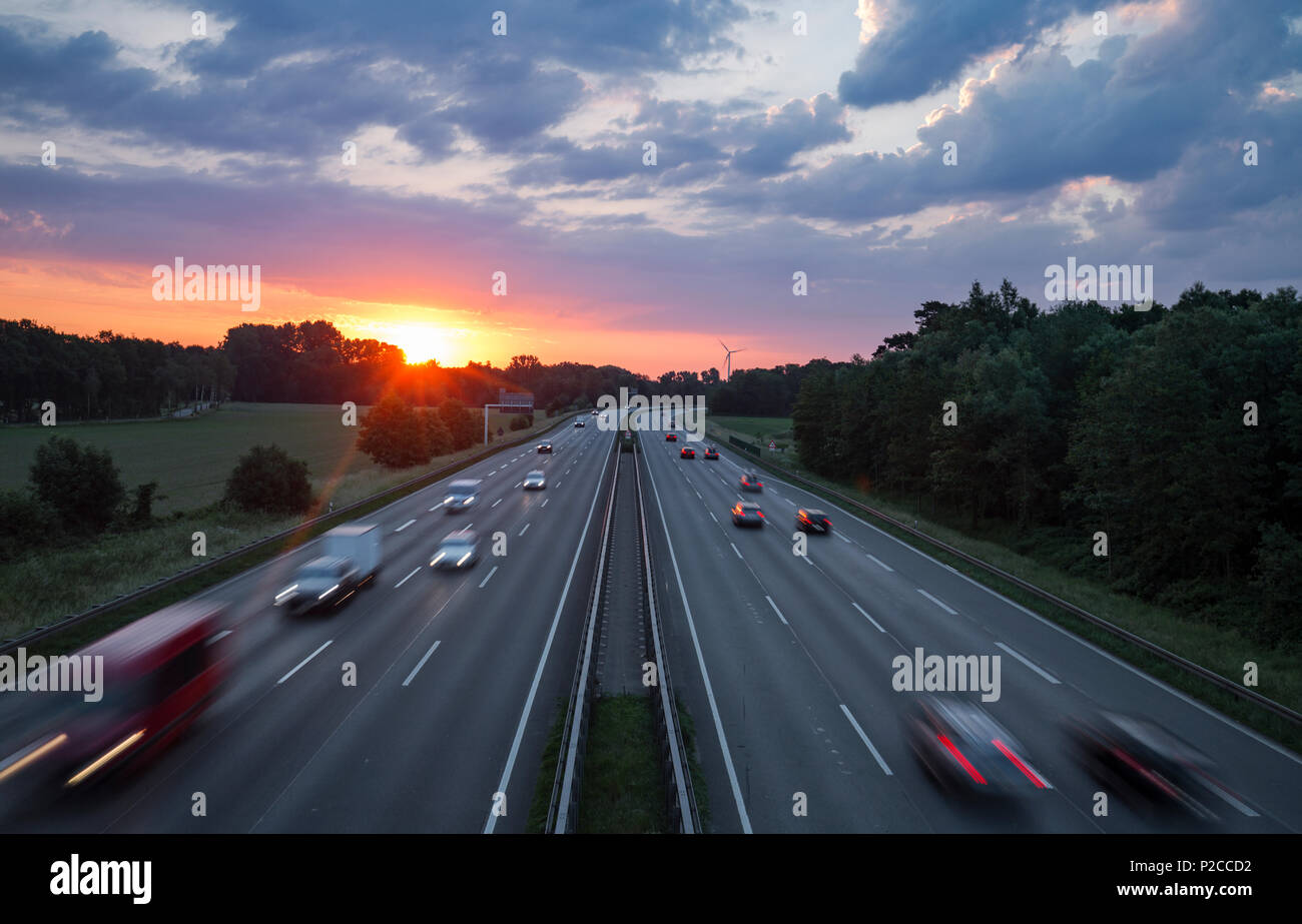 Raising red sun over German motorway with multiple cars blurred in ...