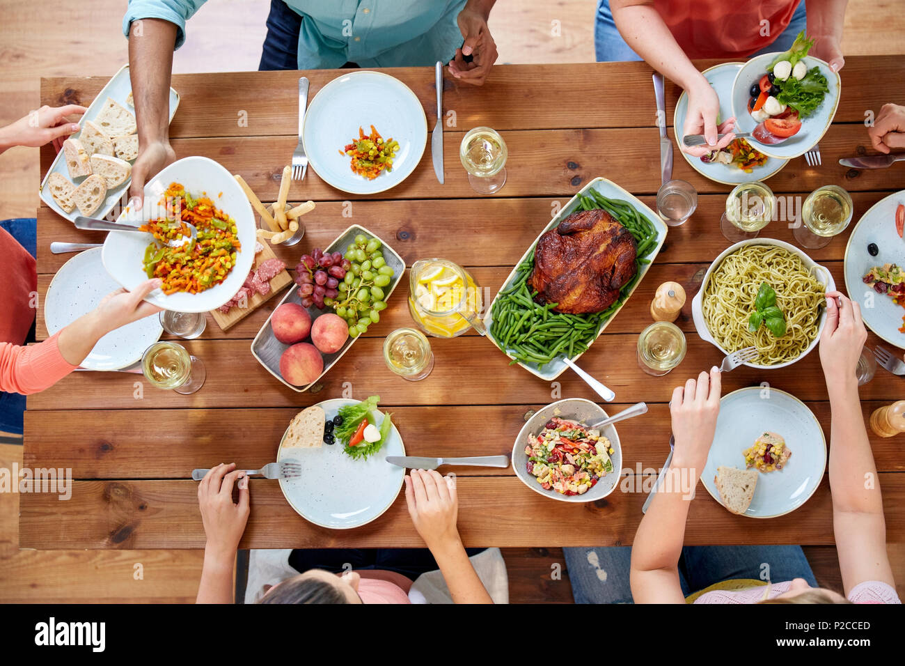 group of people eating at table with food Stock Photo - Alamy