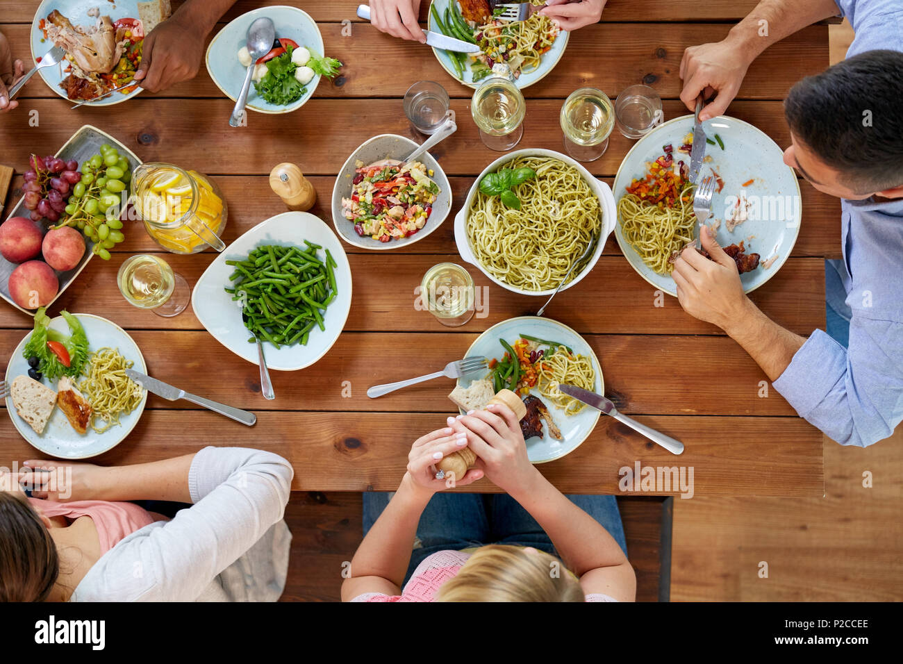 group of people eating at table with food Stock Photo - Alamy