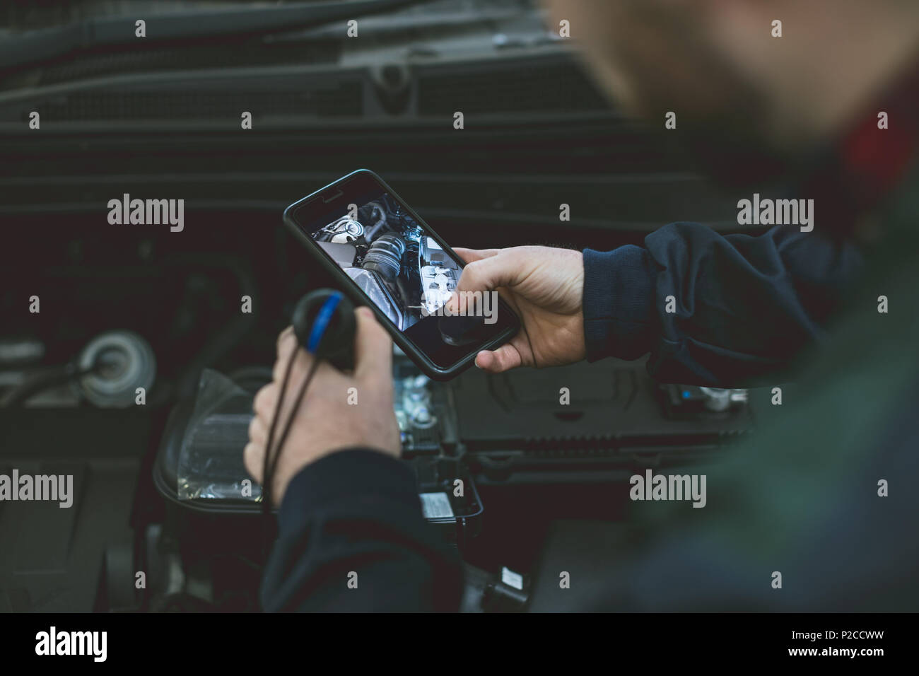 Mechanic taking picture of car engine with mobile phone Stock Photo - Alamy