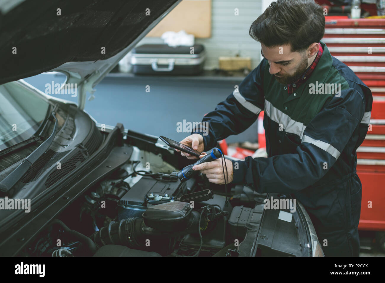 Mechanic taking picture of car engine with mobile phone Stock Photo - Alamy