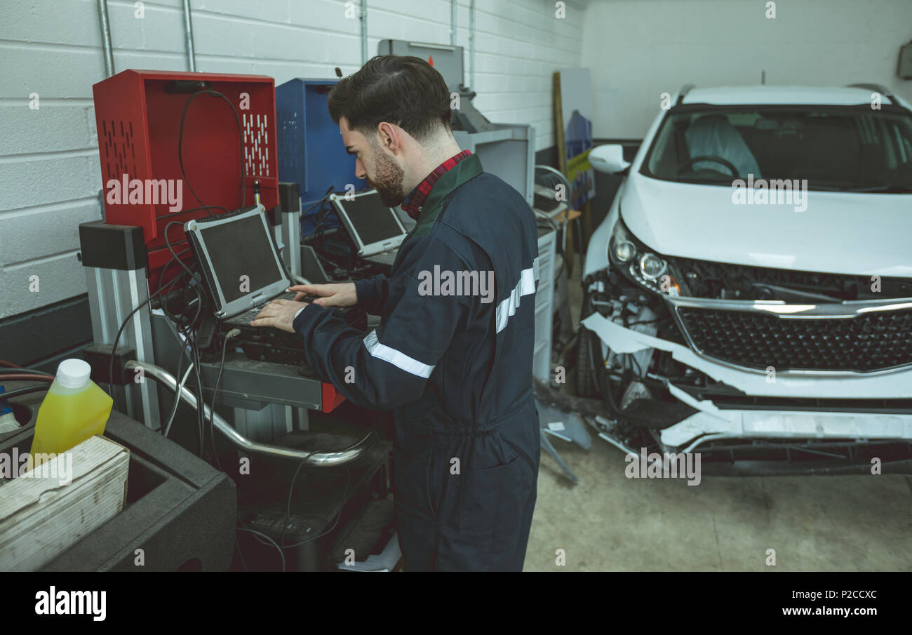 Mechanic using laptop while repairing car Stock Photo - Alamy Mechanic using laptop while repairing car Stock Photo - Alamy