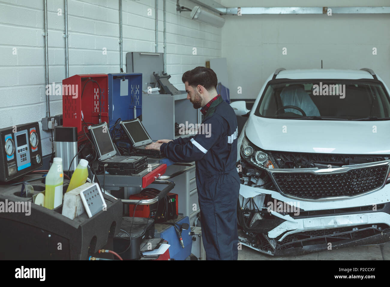 Mechanic using laptop while repairing car Stock Photo - Alamy Mechanic using laptop while repairing car Stock Photo - Alamy