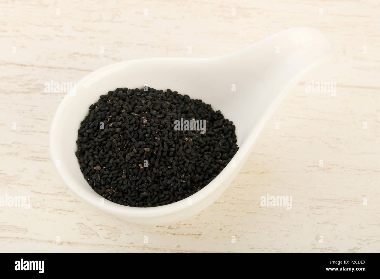 Black nigella seeds heap over wooden background Stock Photo - Alamy