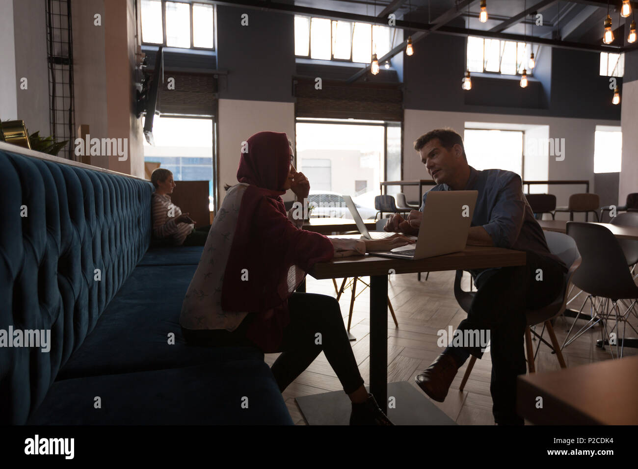 Business colleagues interacting with each other in cafeteria Stock ...