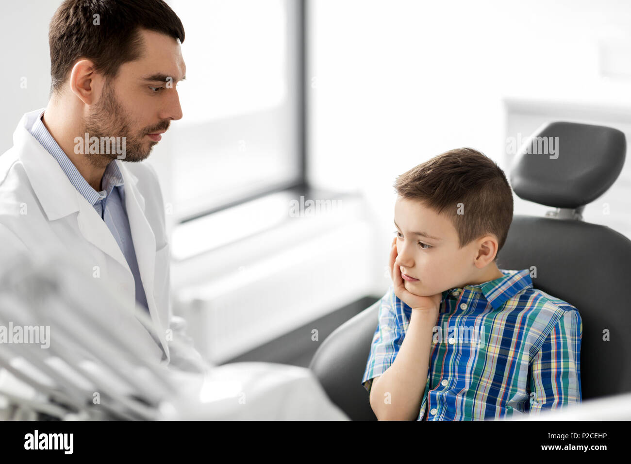 dentist with patient having toothache at clinic Stock Photo - Alamy