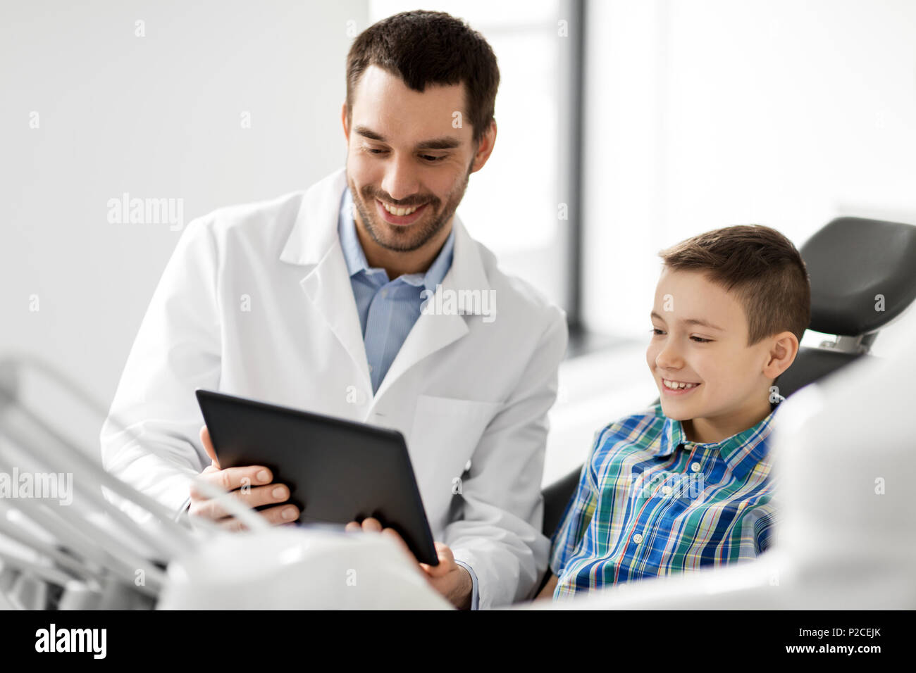 dentist showing tablet pc to kid patient at clinic Stock Photo - Alamy