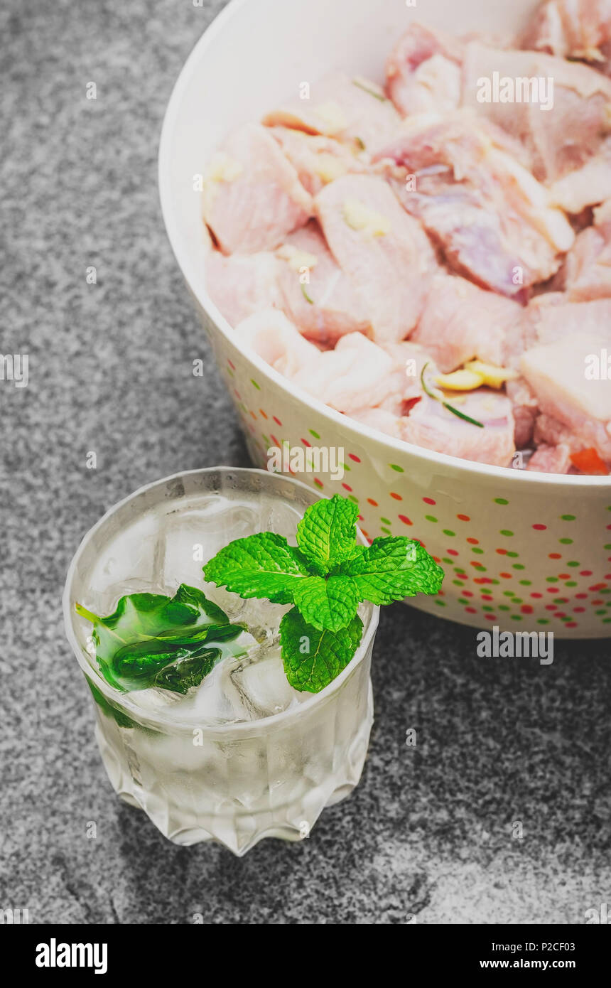 Cup of vodka with mint and seasoned raw pork meat on a bowl on the ...