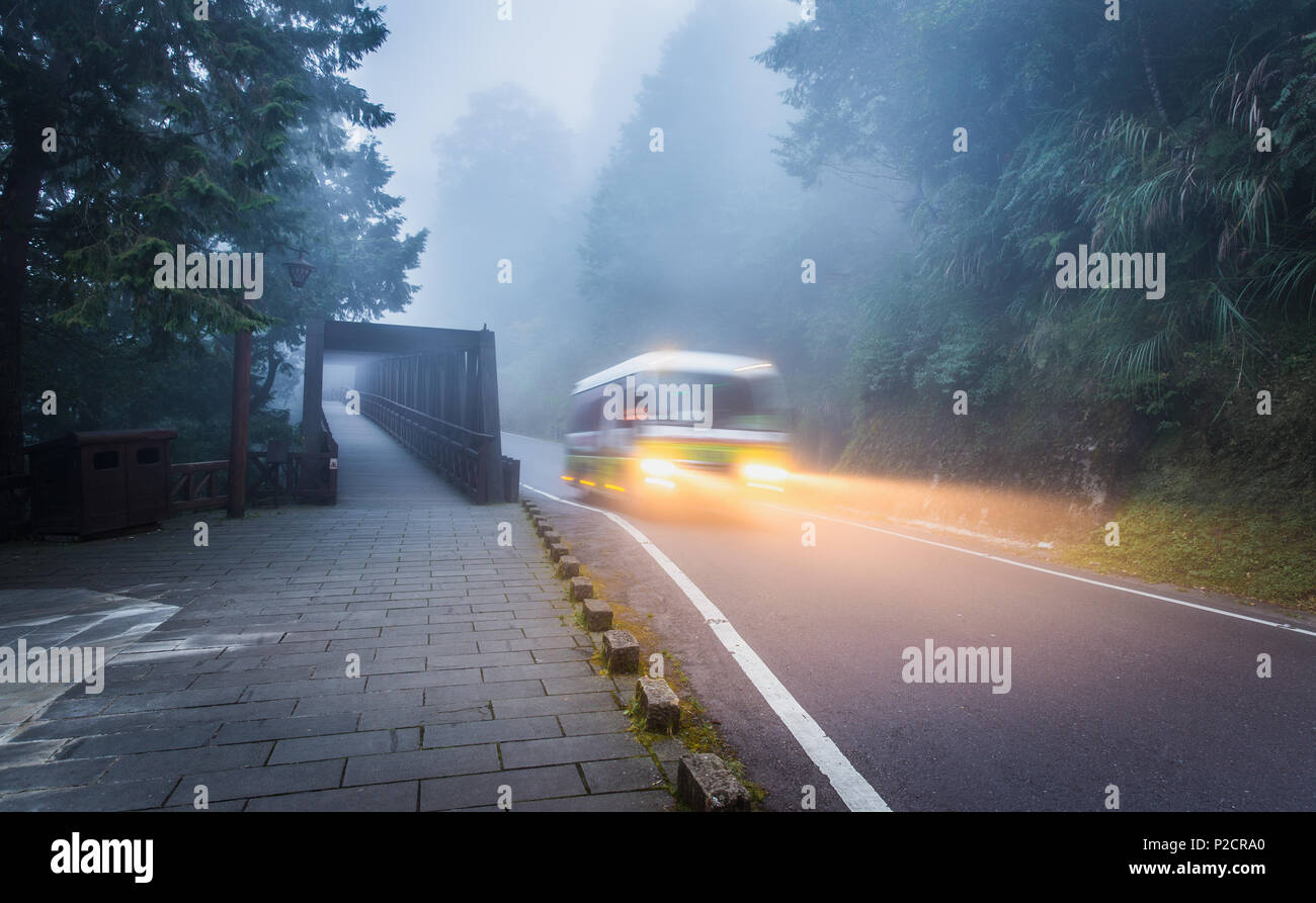 Motion of fast running bus with light on local road near old bridge and ...