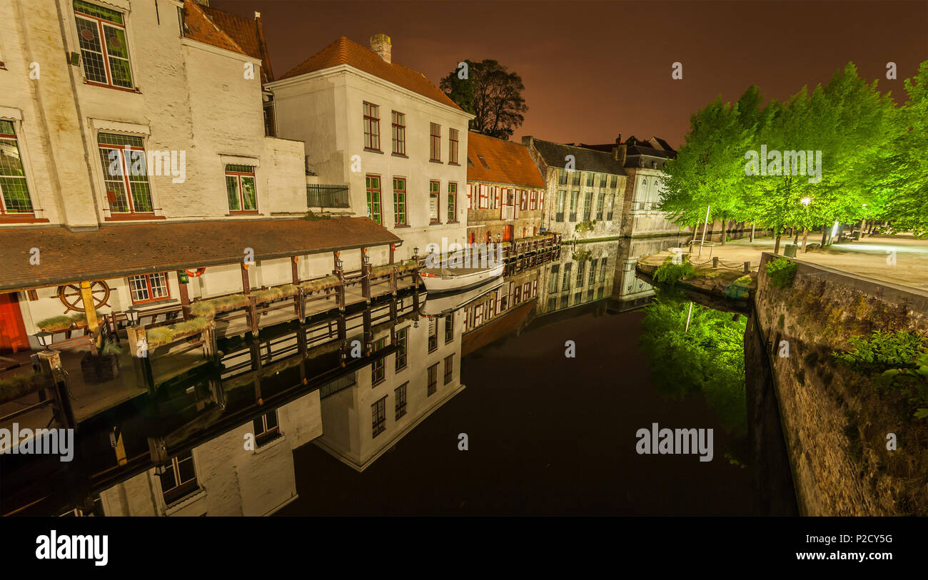 Romantic nocturnal view of a canal in Bruges. Buildings, trees and ...