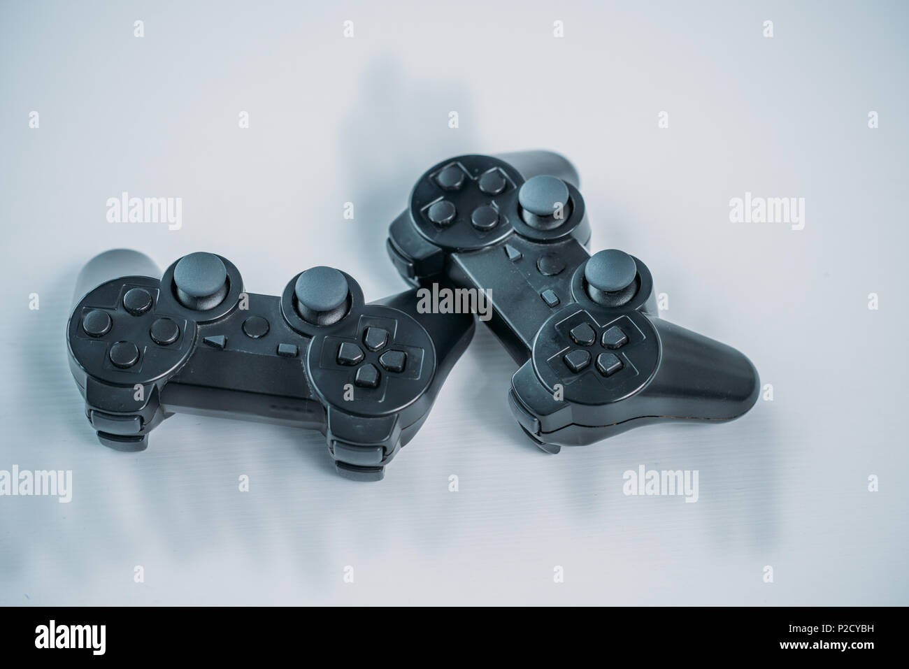 close up view of black gamepads for playing video game on grey tabletop ...