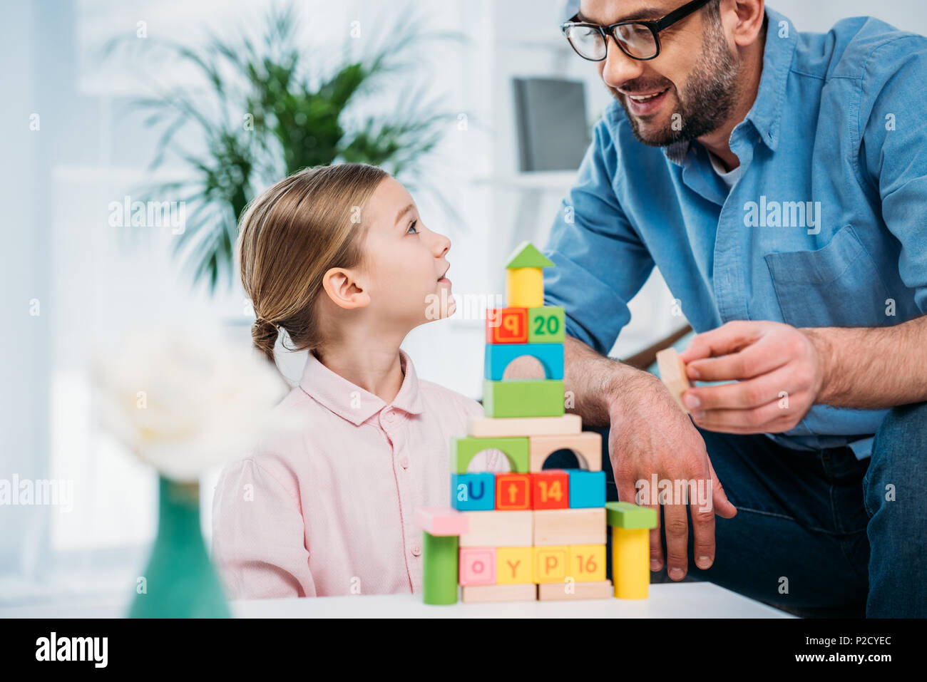 portrait of family building pyramid from colorful blocks at home Stock ...