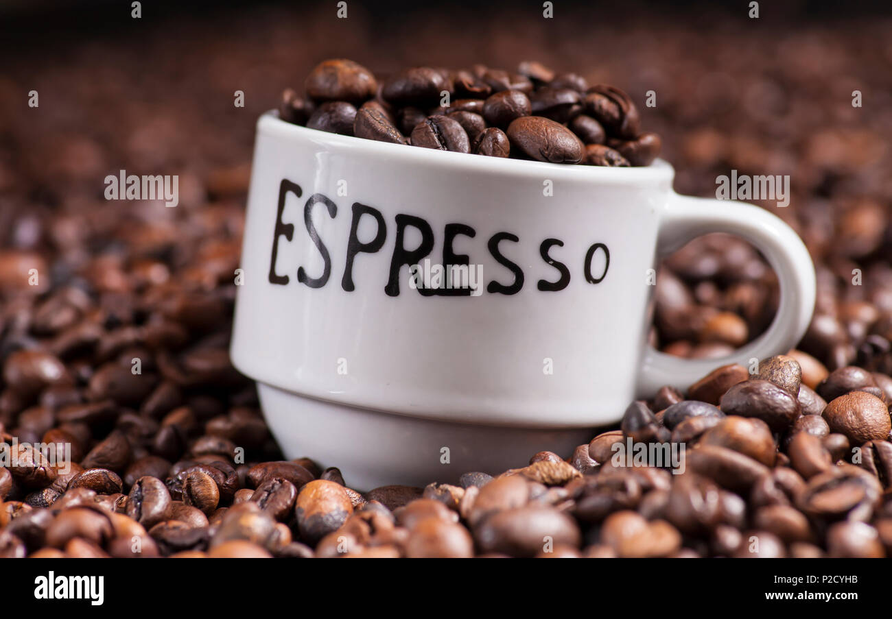 White espresso cup full of coffee beans Stock Photo - Alamy