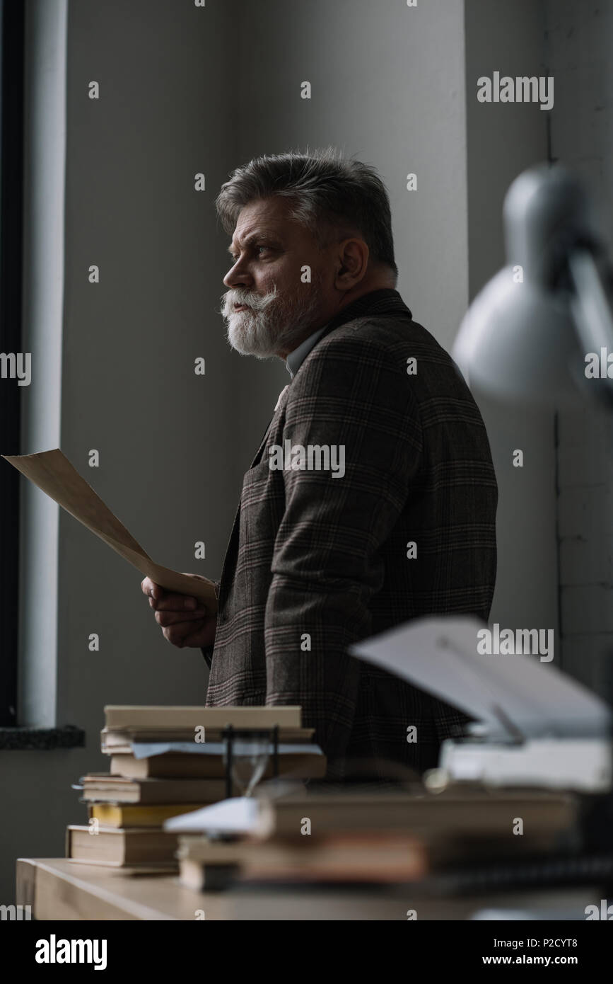 thoughtful senior writer with manuscript looking away Stock Photo - Alamy