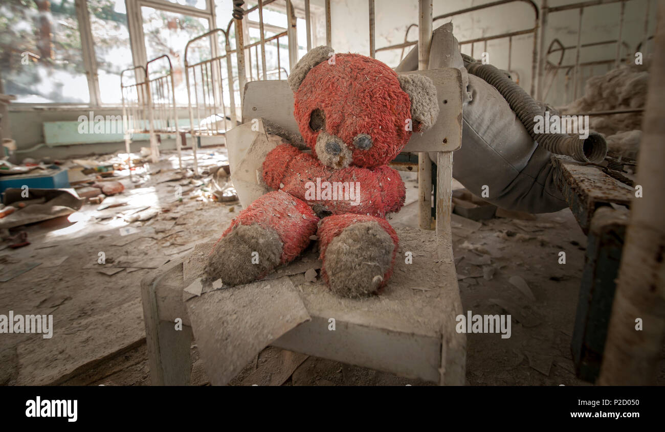 Old red teddy bear sitting on a chair in an abandoned kindergarten in ...