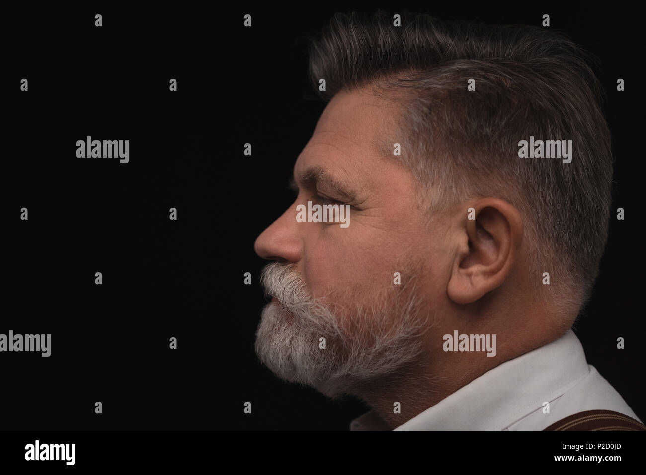 side view of senior man with stylish beard isolated on black Stock ...