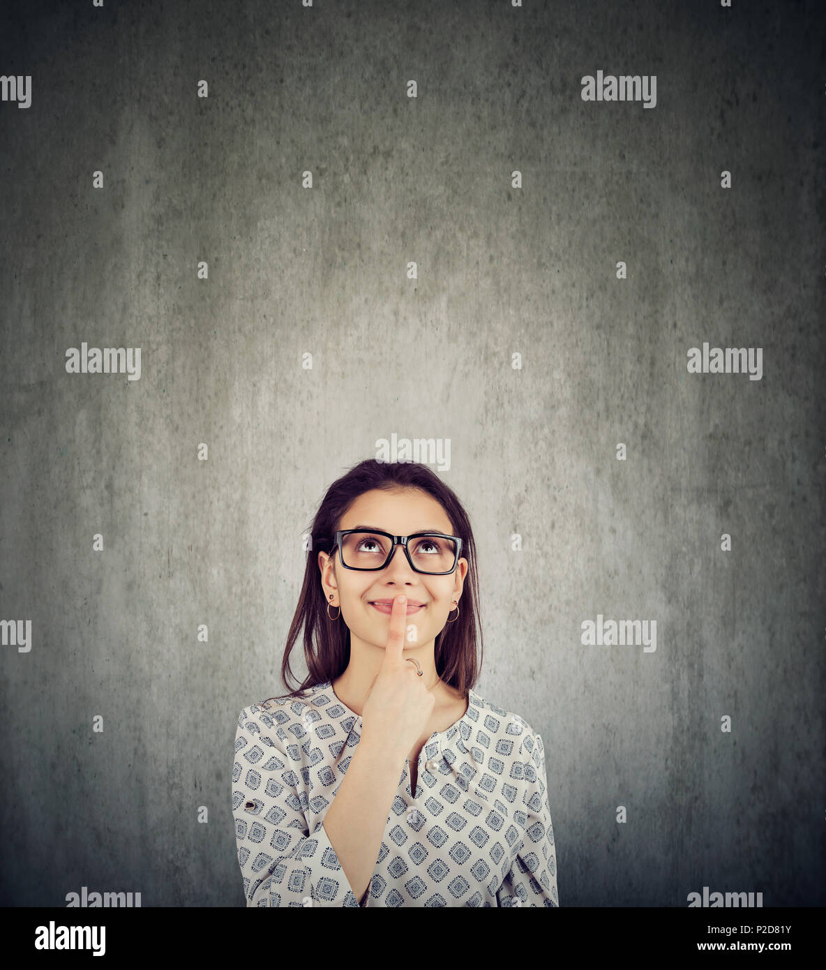 Cute young woman thinking looking up and smiling Stock Photo - Alamy