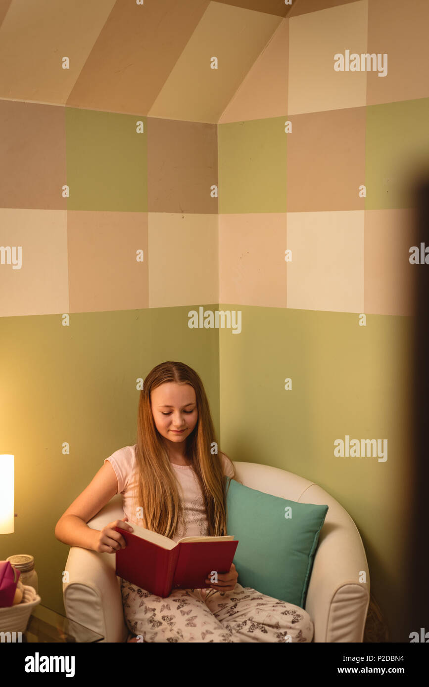 Girl sitting on chair reading hi-res stock photography and images - Alamy