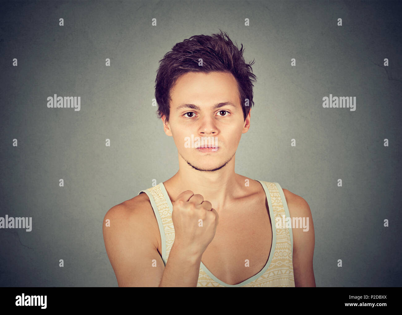 Young teen angry man showing fist and looking aggressively at camera ...