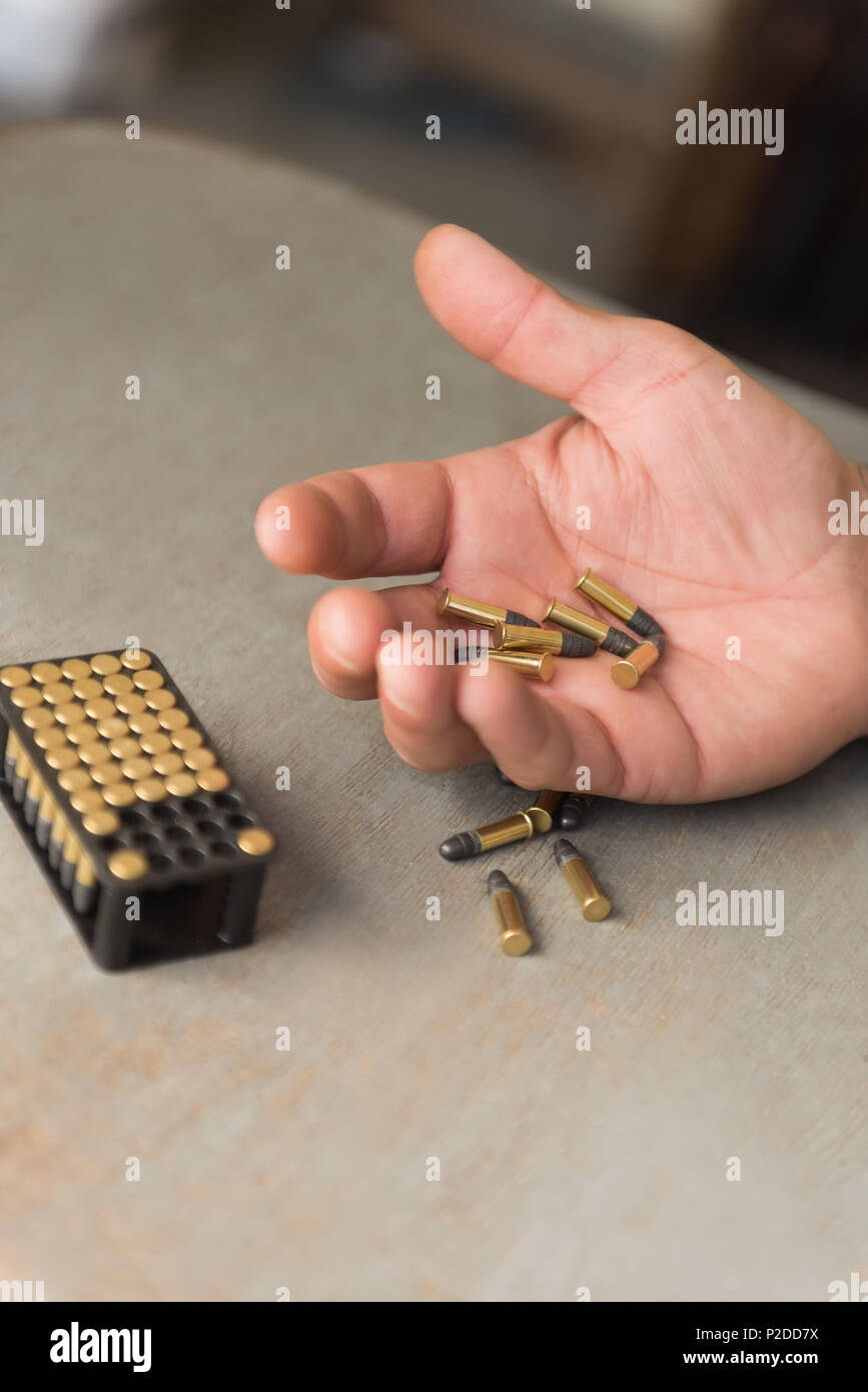 Man holding bullets in hand Stock Photo - Alamy