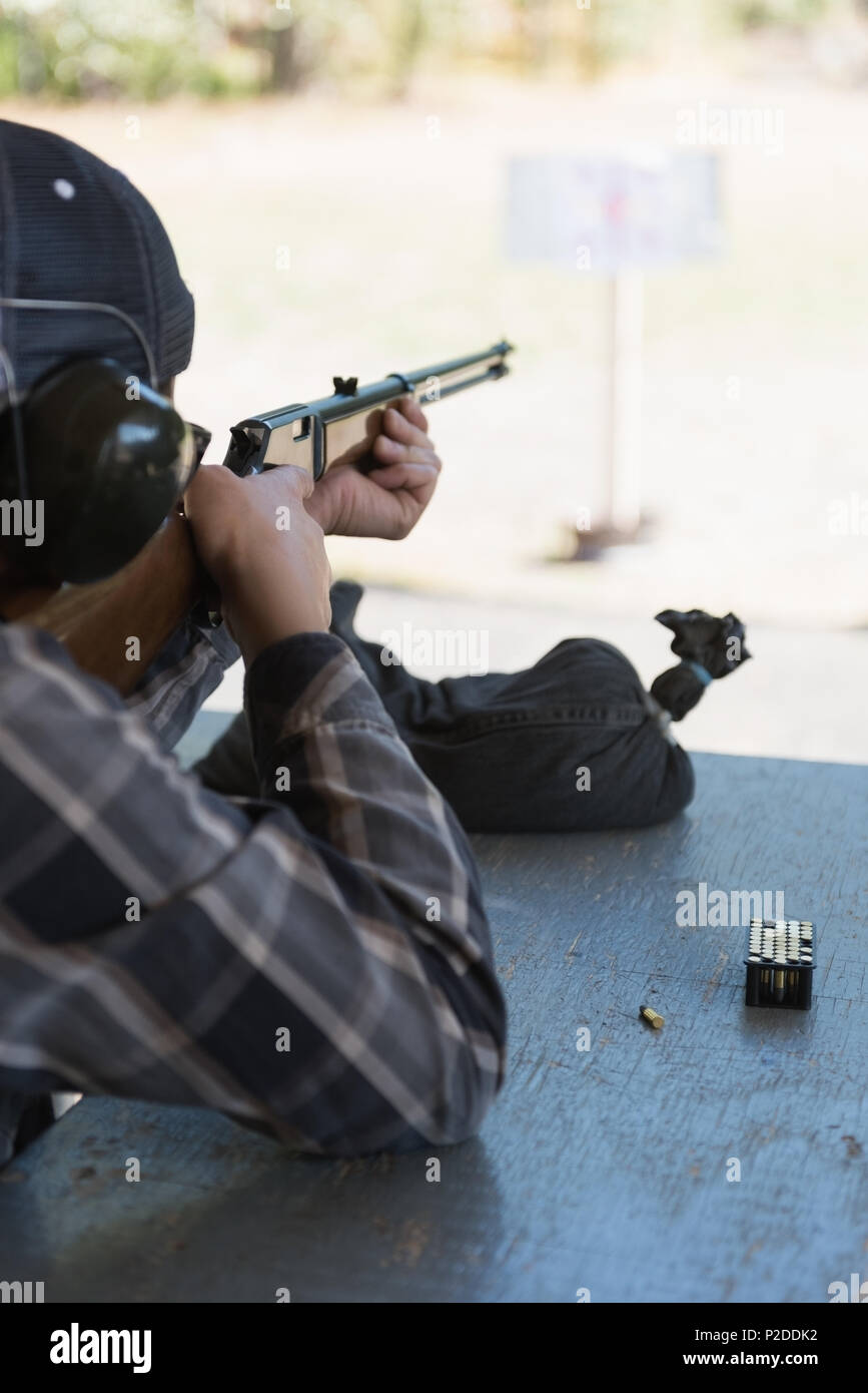 Man aiming shotgun at target in shooting range Stock Photo - Alamy
