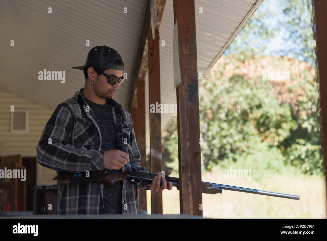 Man loading bullet into shotgun Stock Photo - Alamy