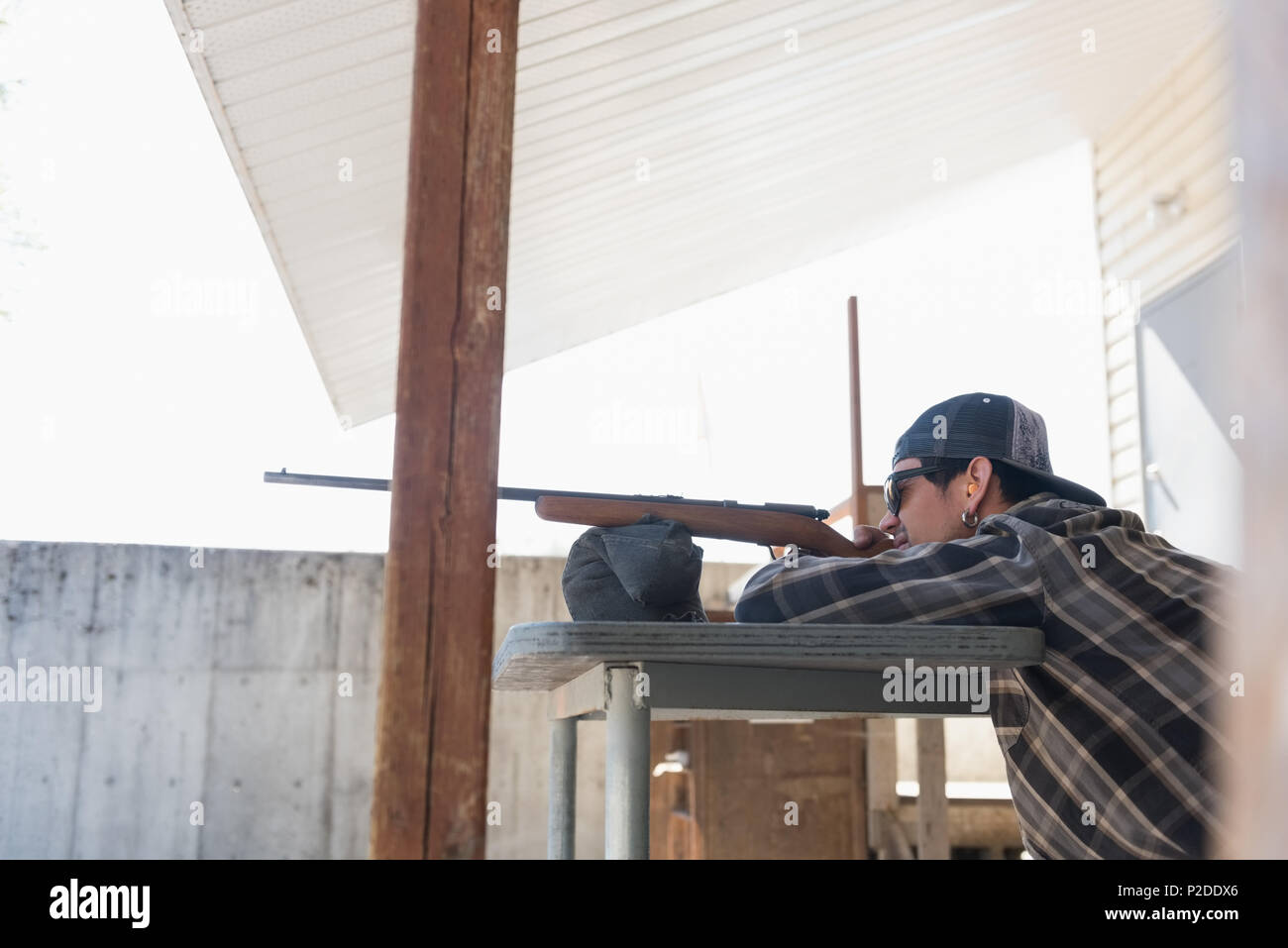 Man aiming shotgun at target in shooting range Stock Photo - Alamy