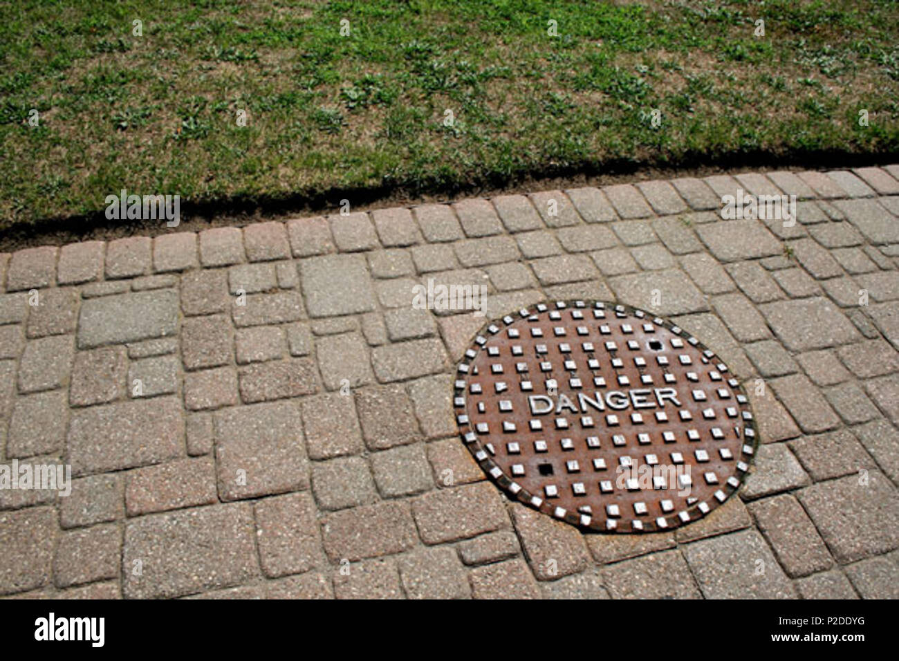 . English: picture of a manhole with interlocking bricks and grass. 11 ...