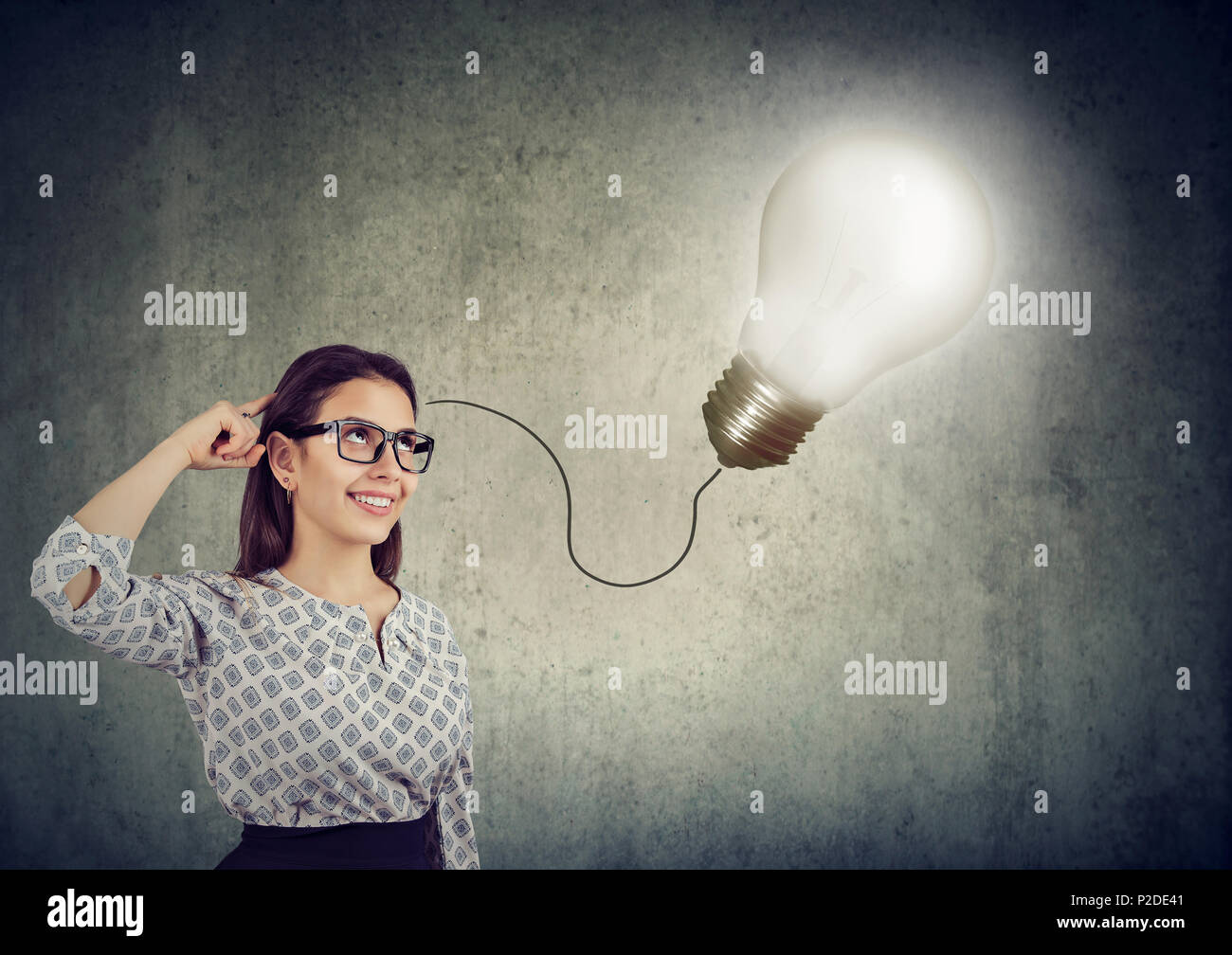 Smiling beautiful young woman having an idea with light bulb over her head Stock Photo - Alamy