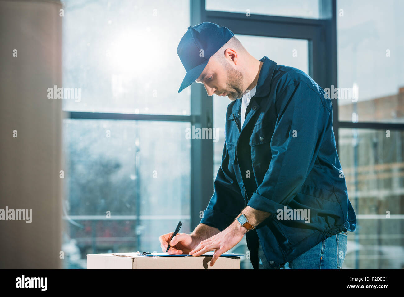 Courier checking cardboard box and cargo declaration Stock Photo - Alamy