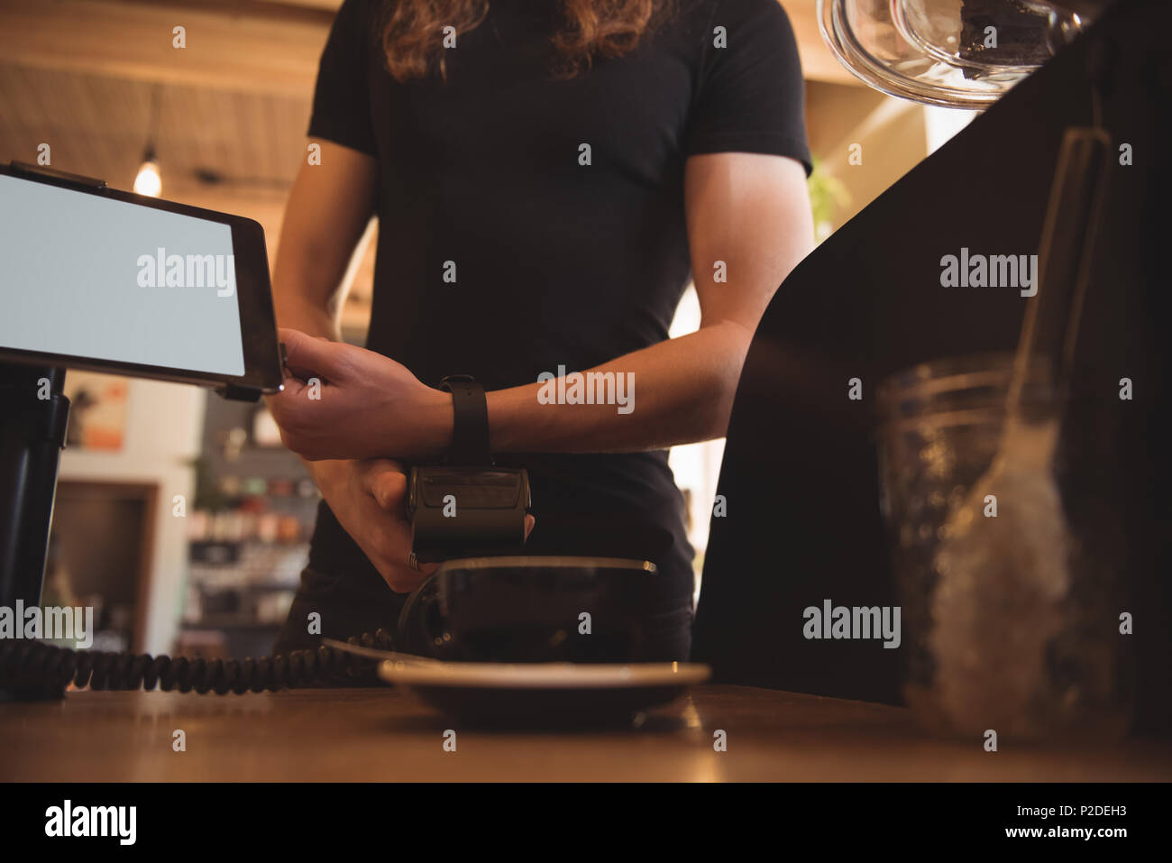Customer making payment with smartwatch at counter Stock Photo - Alamy