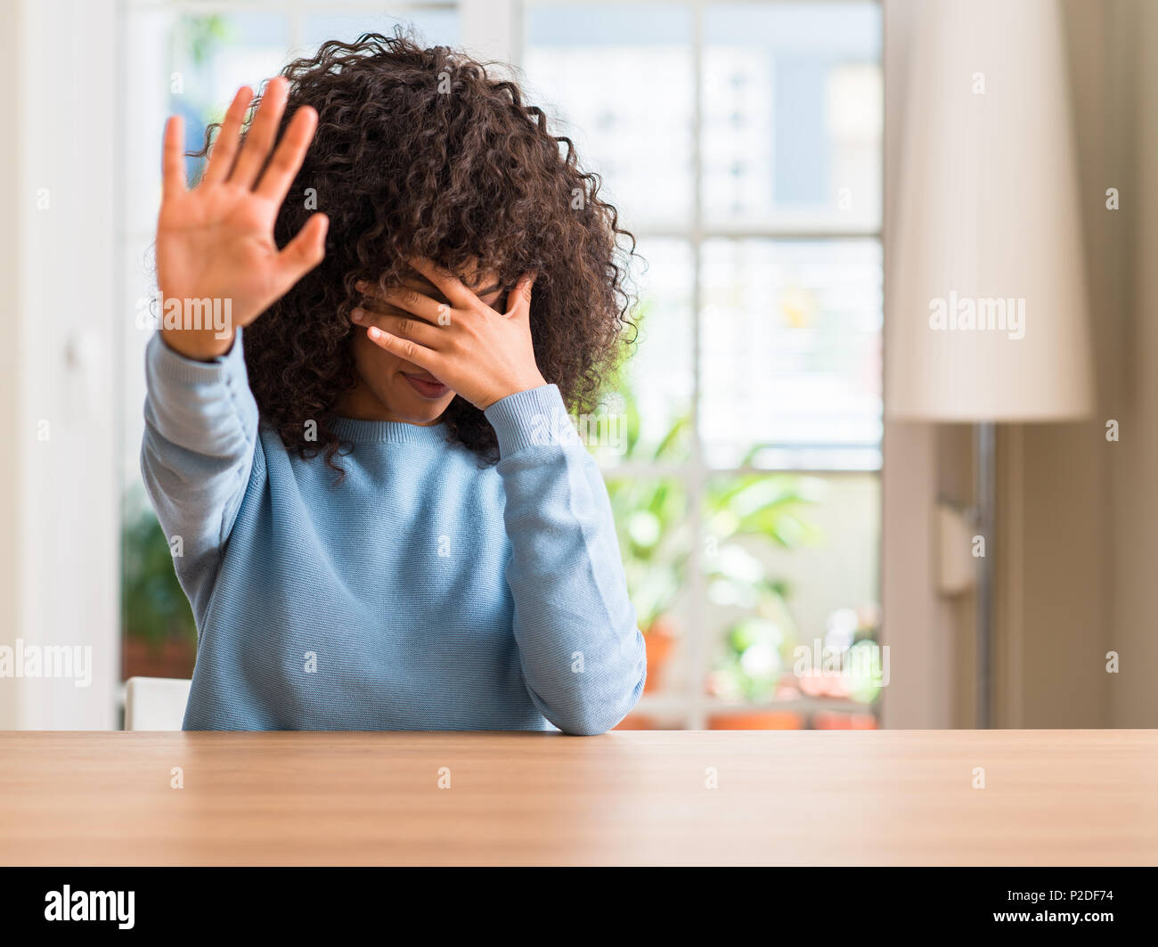 African american woman at home covering eyes with hands and doing stop ...