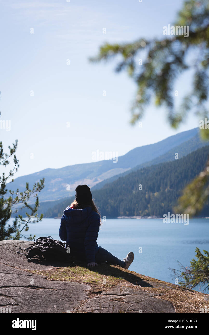 Female hiker sitting on rock Stock Photo - Alamy
