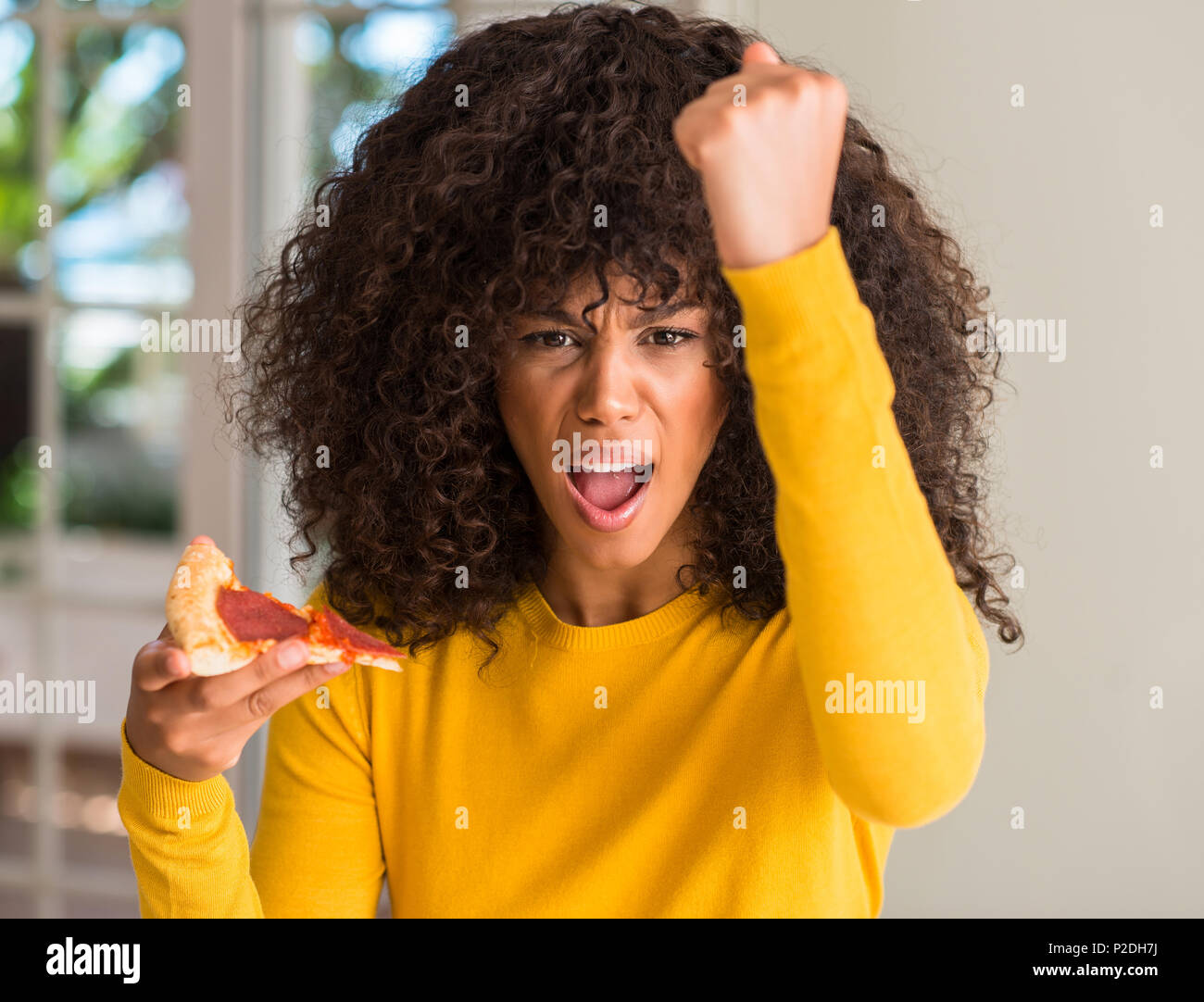African american woman ready to eat pepperoni pizza slice annoyed and ...