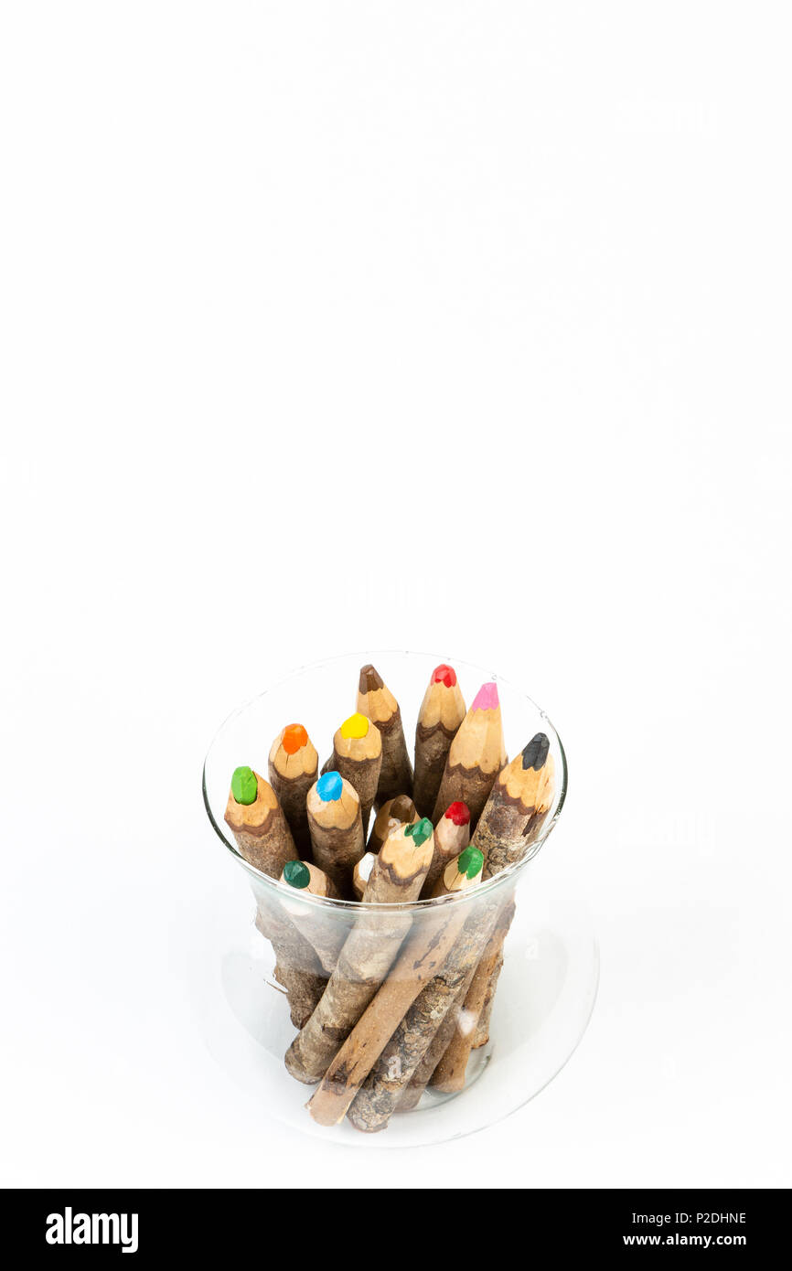 Close up of handmade wooden color pencils inside glass pot on white ...