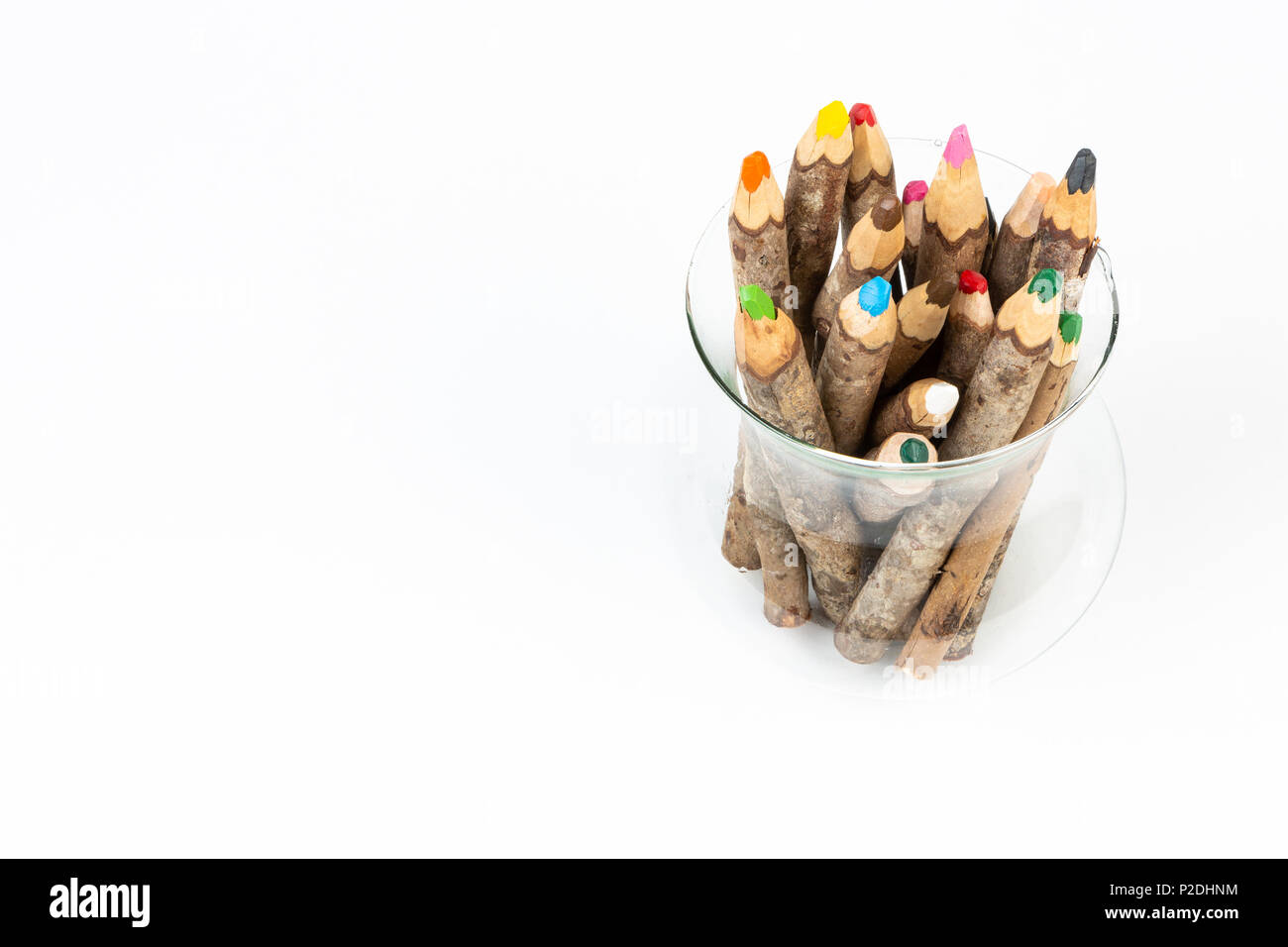Close up of handmade wooden color pencils inside glass pot on white ...