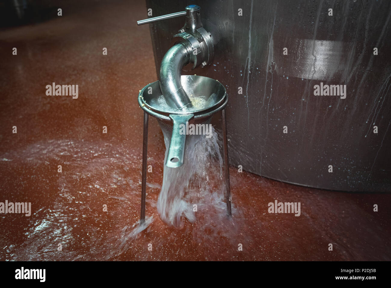 Liquid being filtered and overflowing from the tank Stock Photo - Alamy