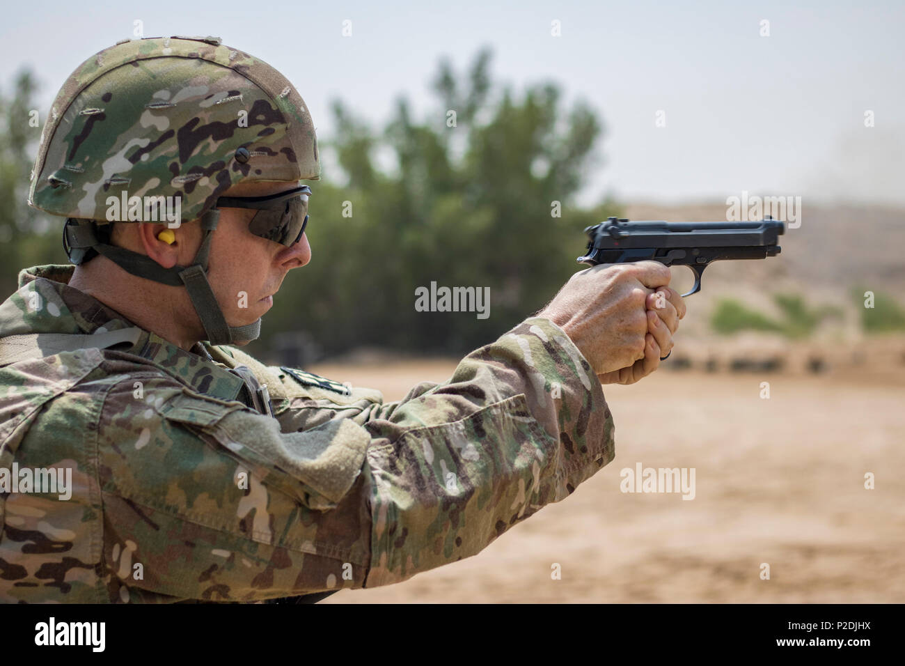 A U.S. Soldier fires at his target during the M9 pistol marksmanship ...